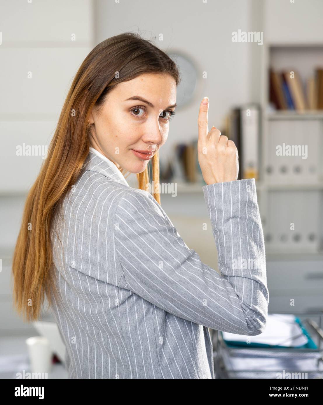 Business woman standing in office and pointing Stock Photo - Alamy