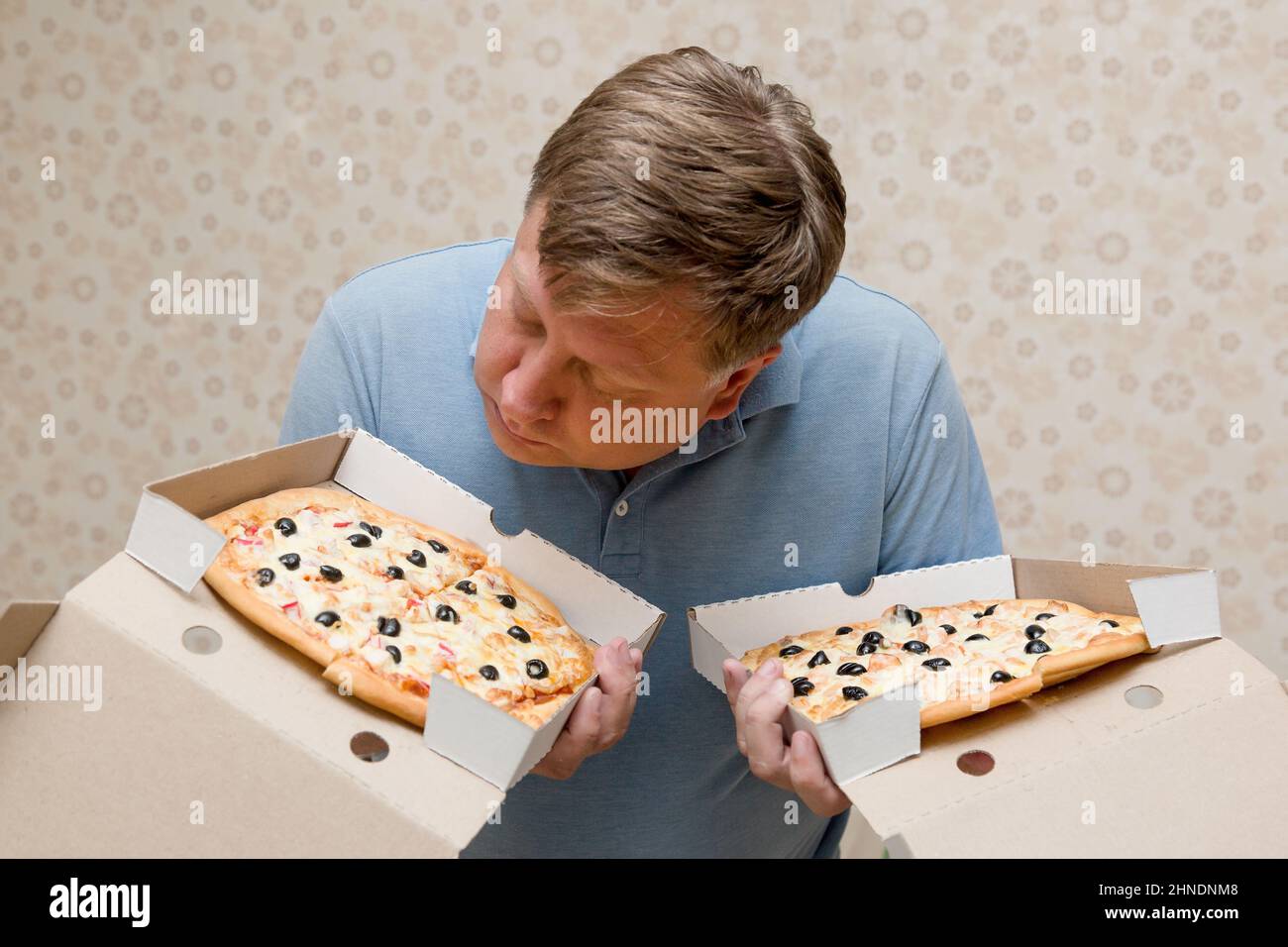 fat man bought two boxes pizza and sniffs them with pleasure Stock ...