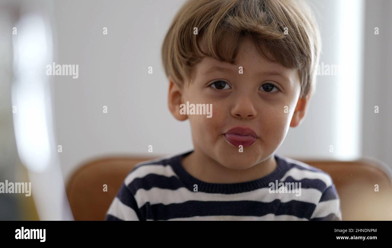 Cute little boy spitting to camera sticking tongue out being playful ...