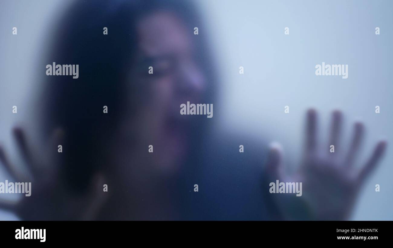Defocused shot of person trapped in emotional problems behind glass ...