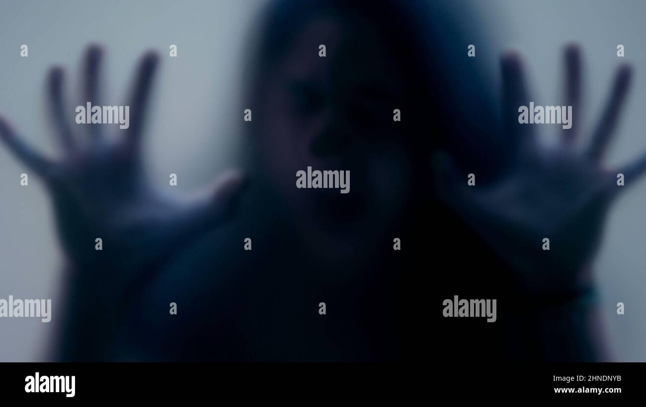 Defocused shot of person trapped in emotional problems behind glass ...