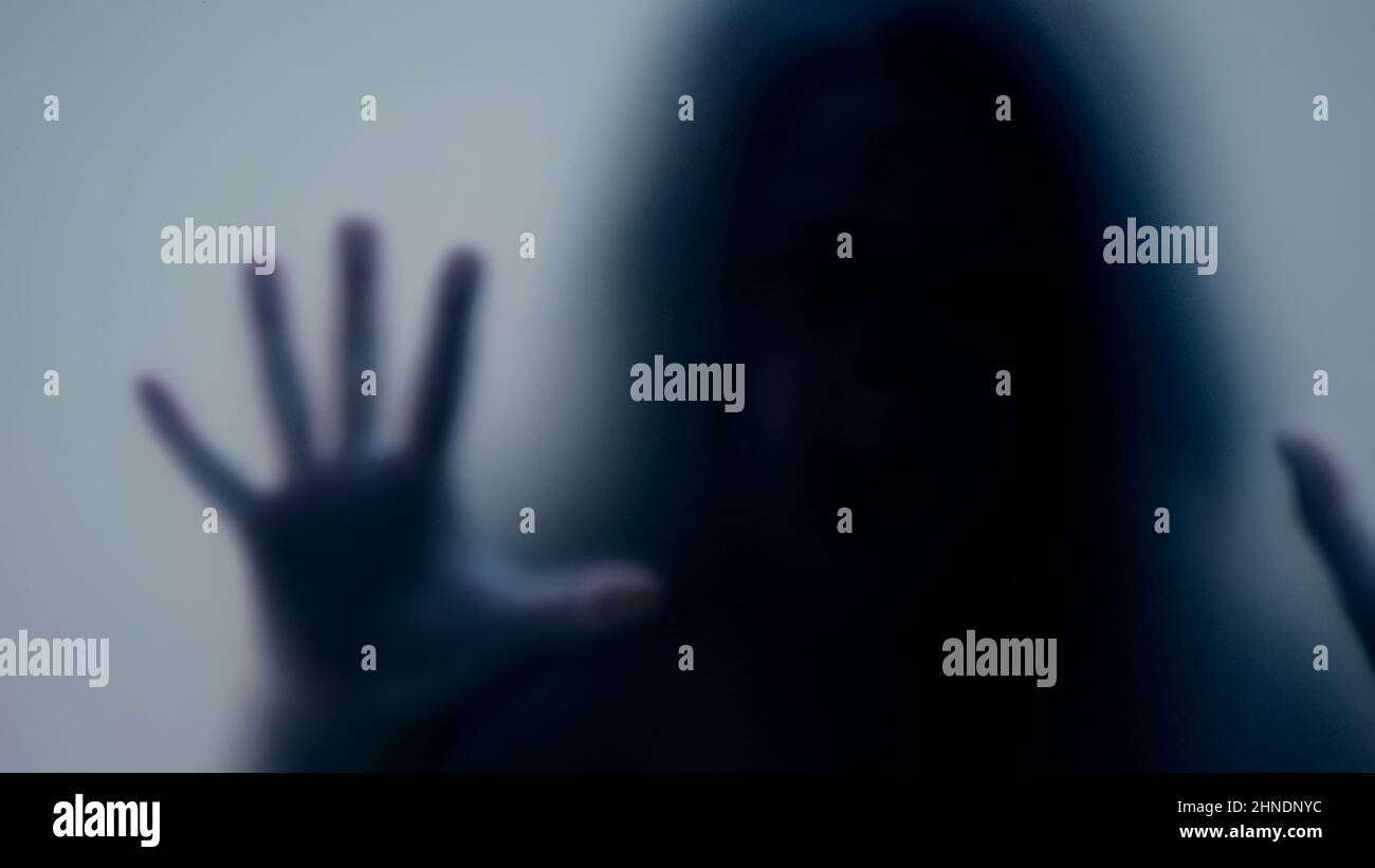 Defocused shot of person trapped in emotional problems behind glass ...