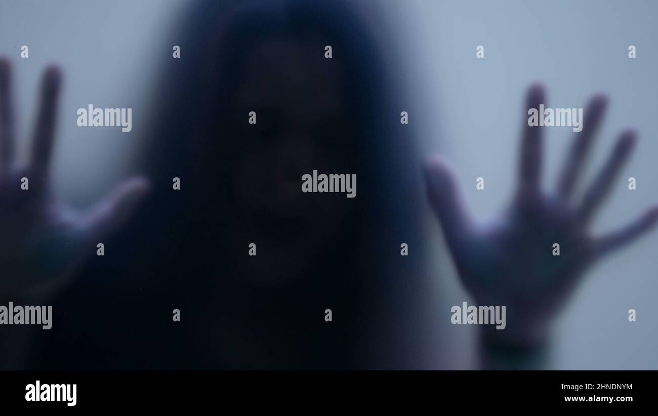 Defocused shot of person trapped in emotional problems behind glass ...
