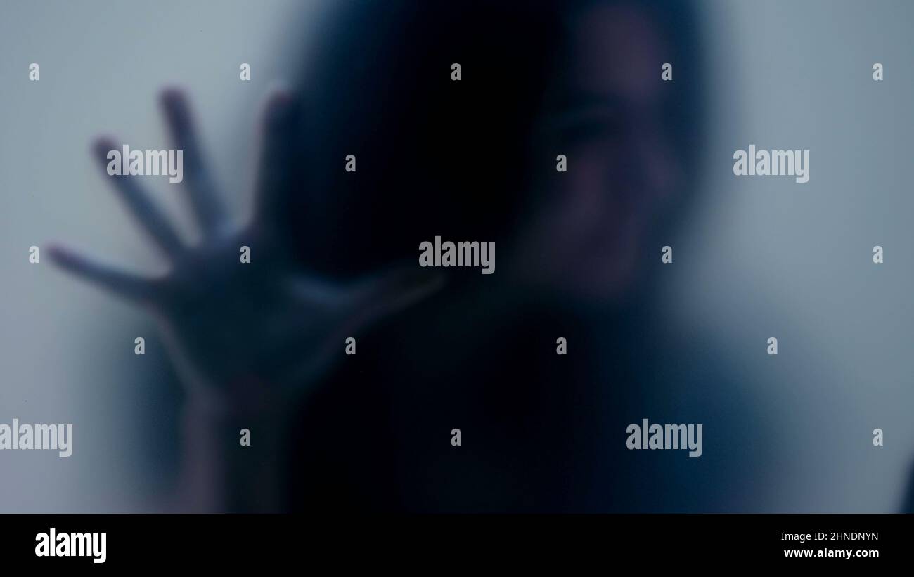 Defocused shot of person trapped in emotional problems behind glass ...