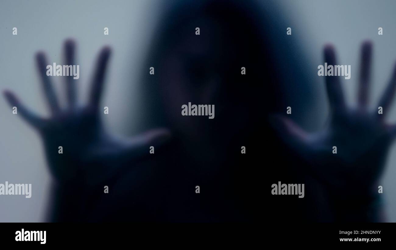 Defocused shot of person trapped in emotional problems behind glass ...