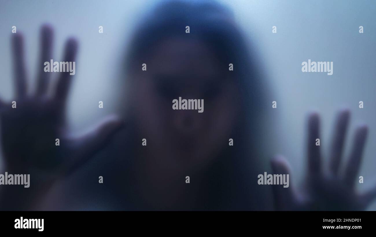 Defocused shot of person trapped in emotional problems behind glass ...