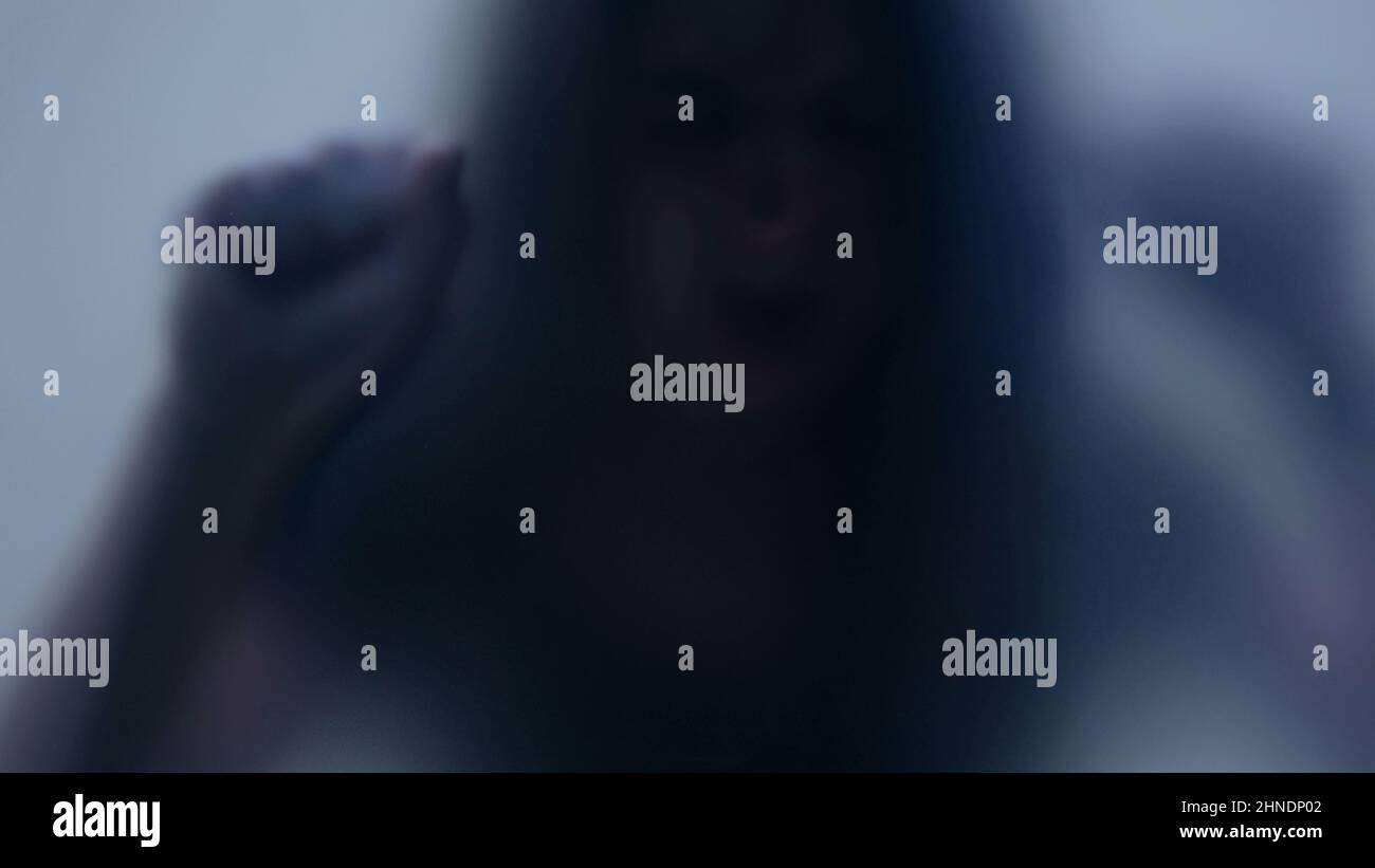 Defocused shot of person trapped in emotional problems behind glass ...