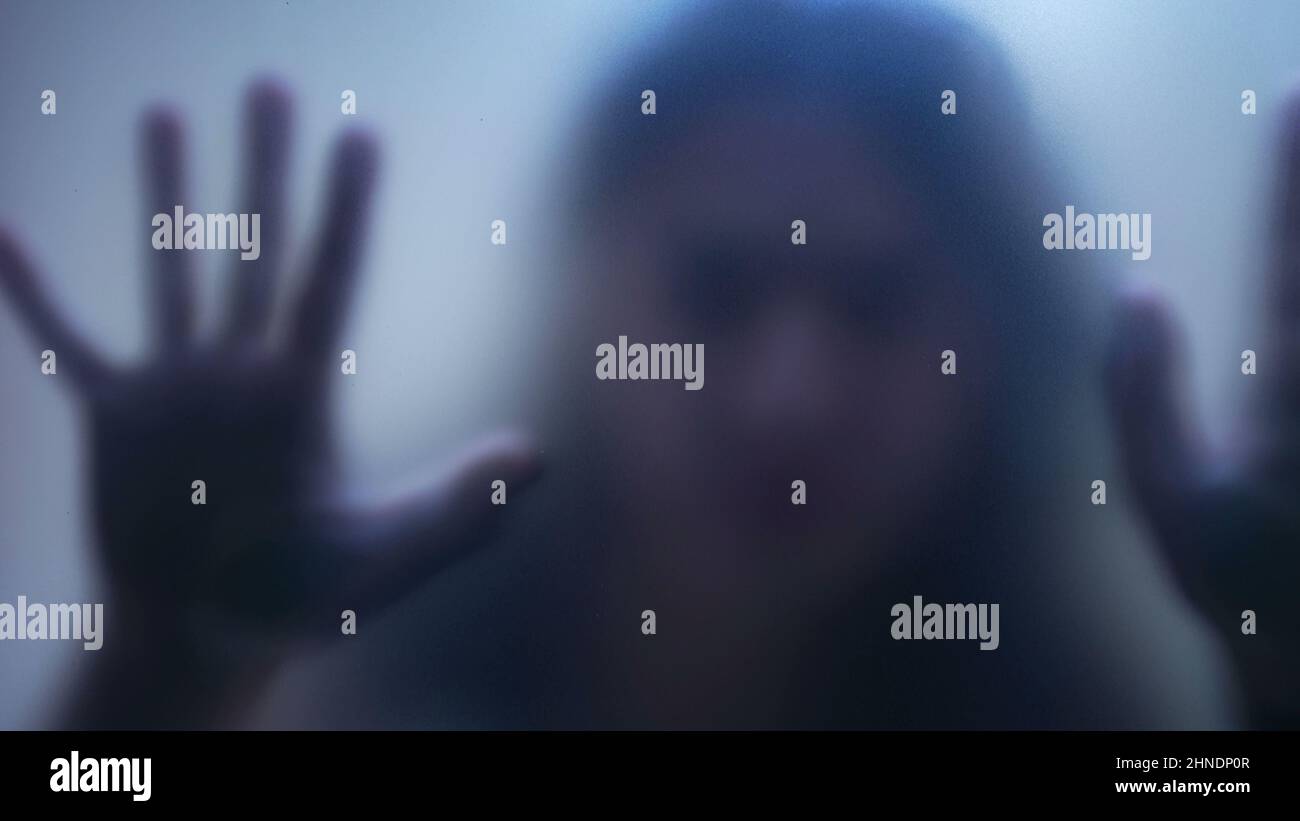 Defocused shot of person trapped in emotional problems behind glass ...