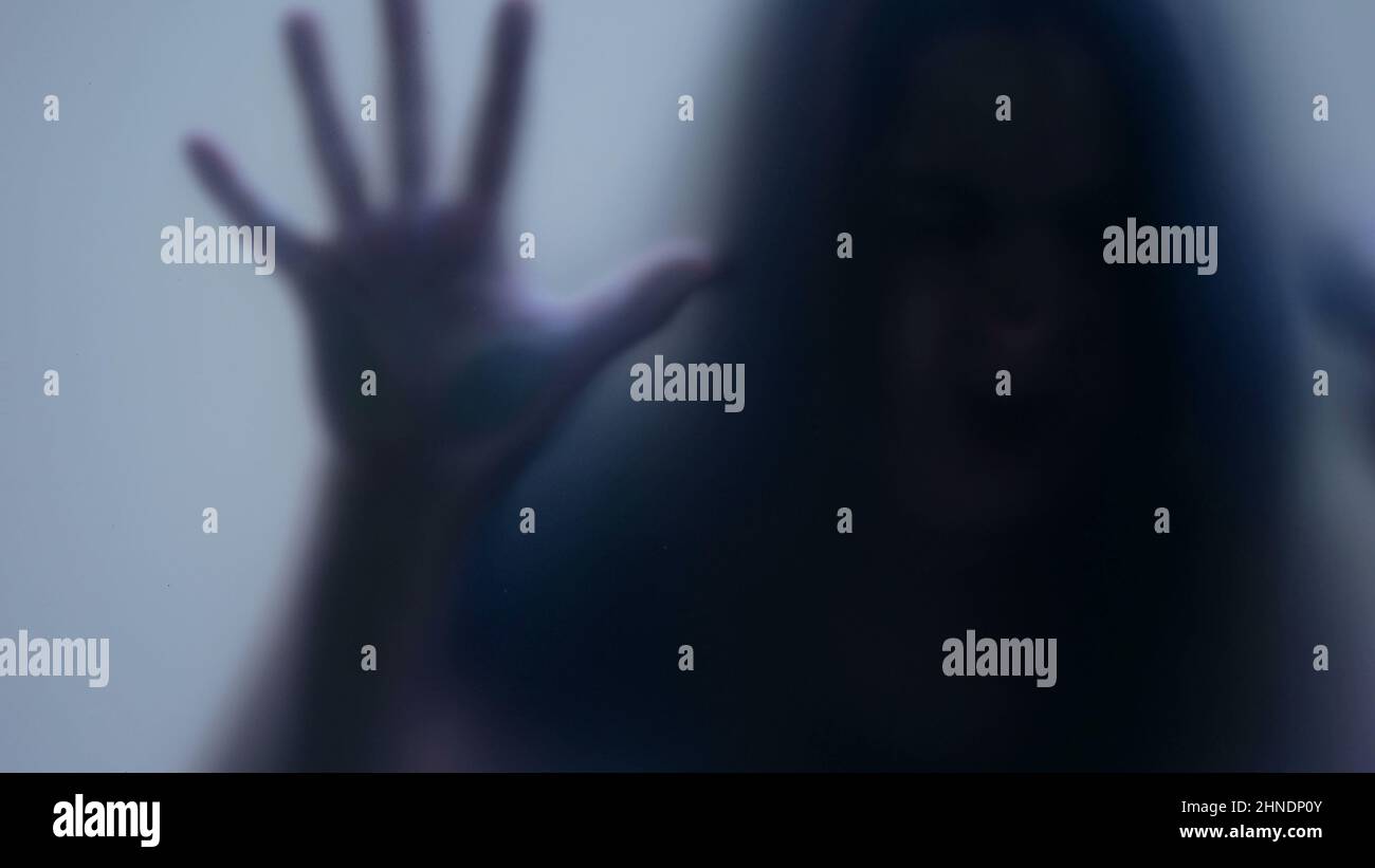 Defocused shot of person trapped in emotional problems behind glass ...