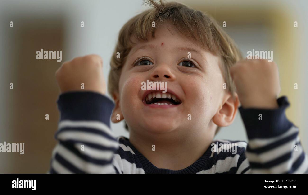 Happy child hitting table with elbows wanting attention Stock Photo - Alamy