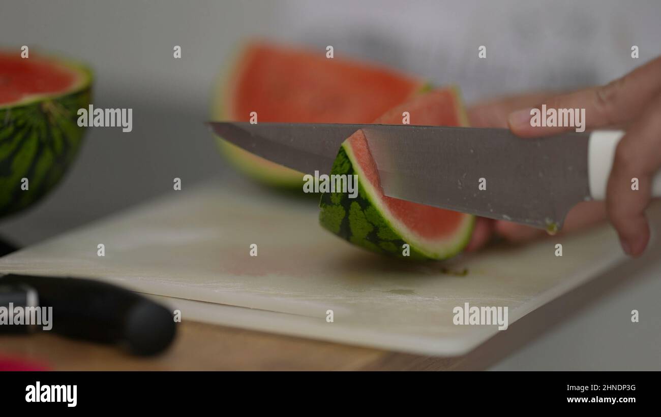 Hand cutting watermelon fruit in slices pieces Stock Photo - Alamy