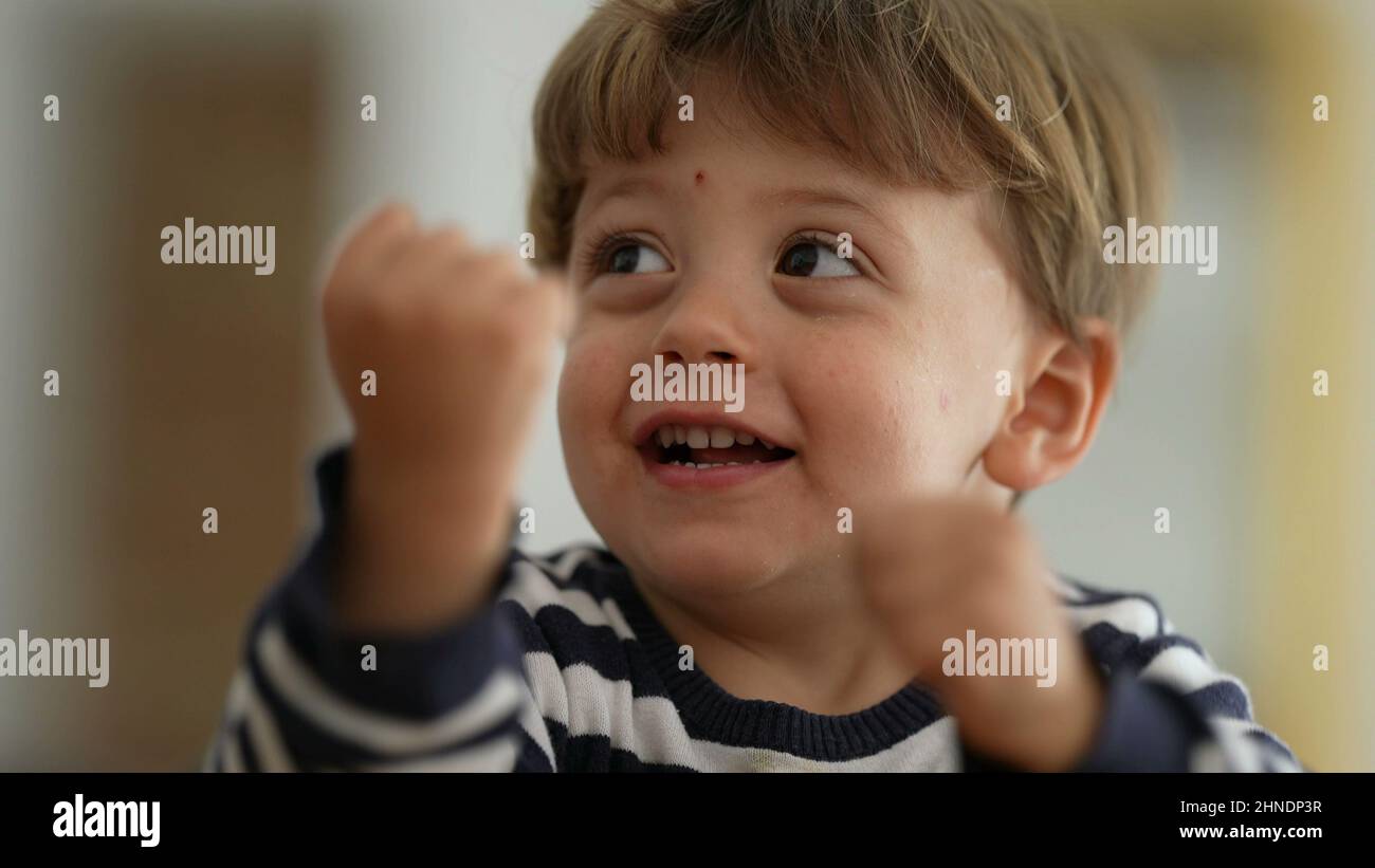 Happy child hitting table with elbows wanting attention Stock Photo - Alamy