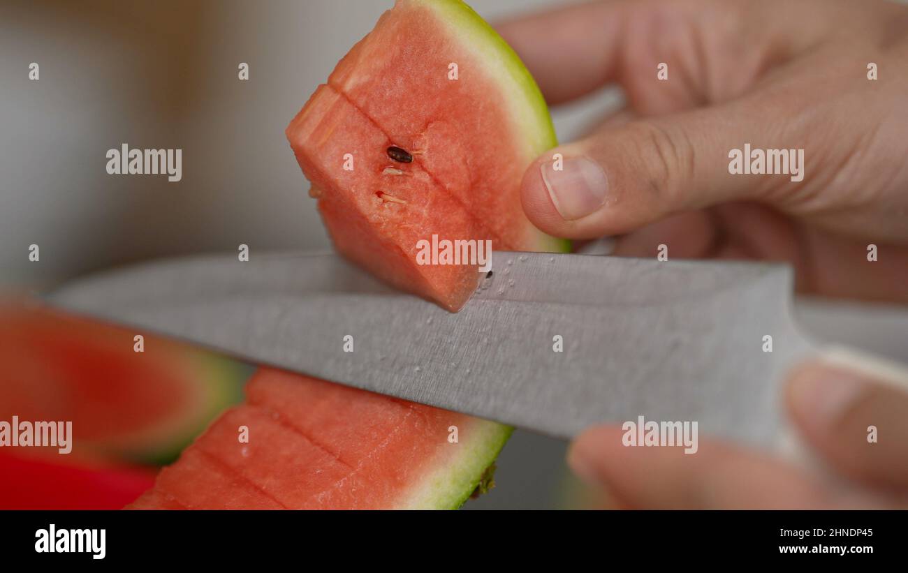 Hand cutting watermelon fruit in slices pieces Stock Photo - Alamy