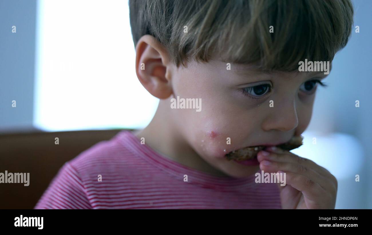 Little boy eating piece of bread child eats carb food Stock Photo - Alamy