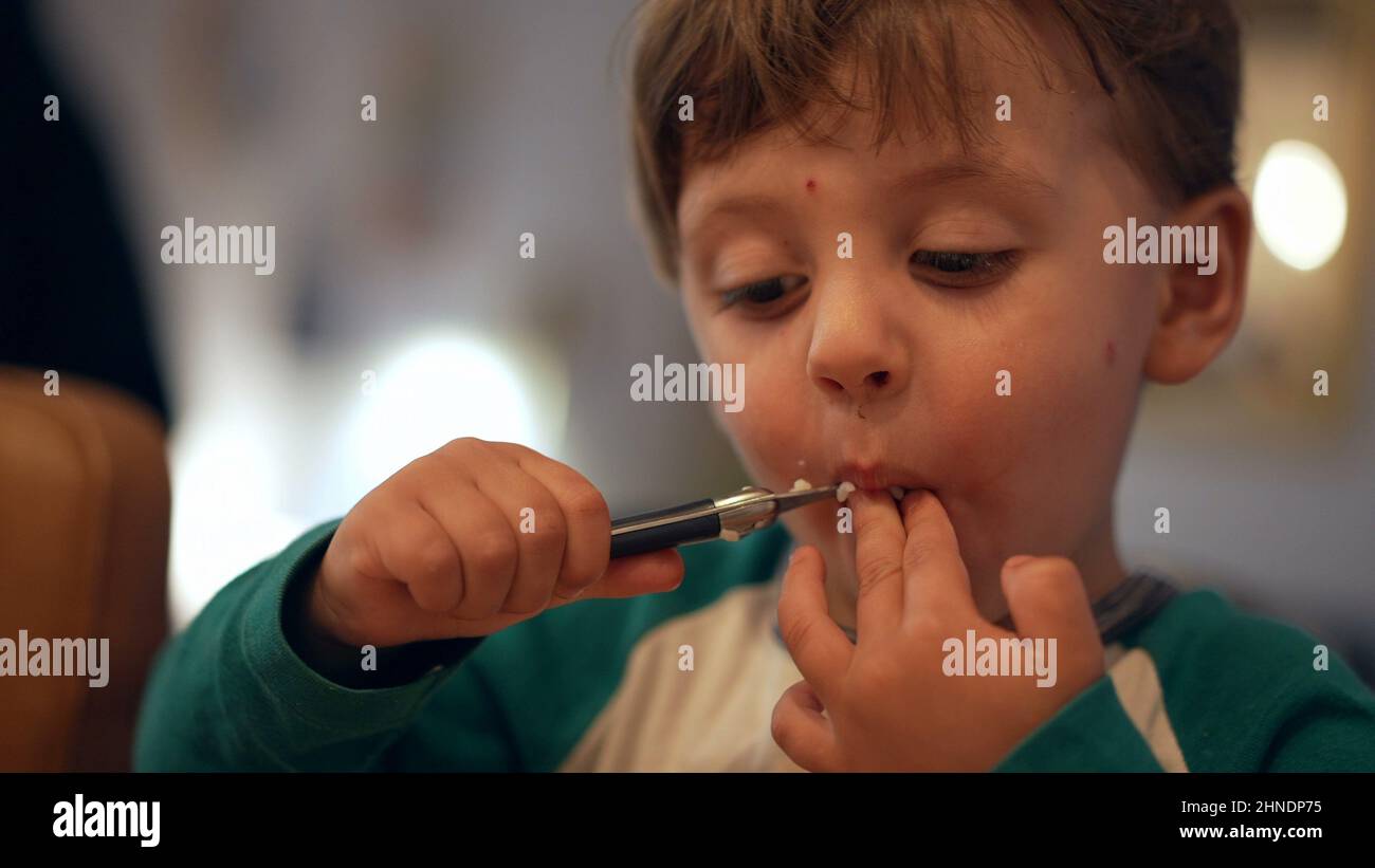 Little boy eating rice with spoon. Child eats food by himself Stock ...