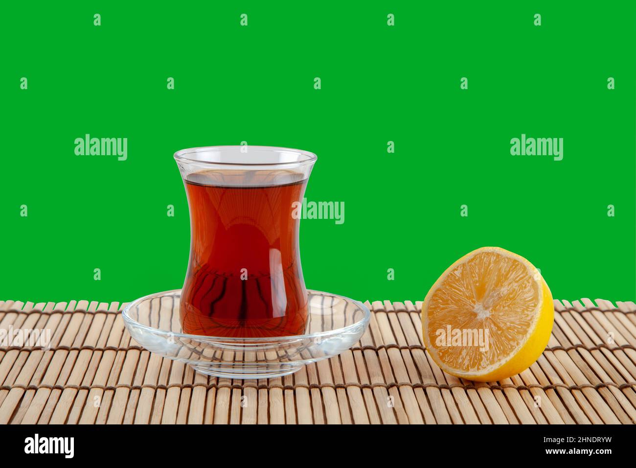Glass of turkish tea and lemon on green background Stock Photo - Alamy