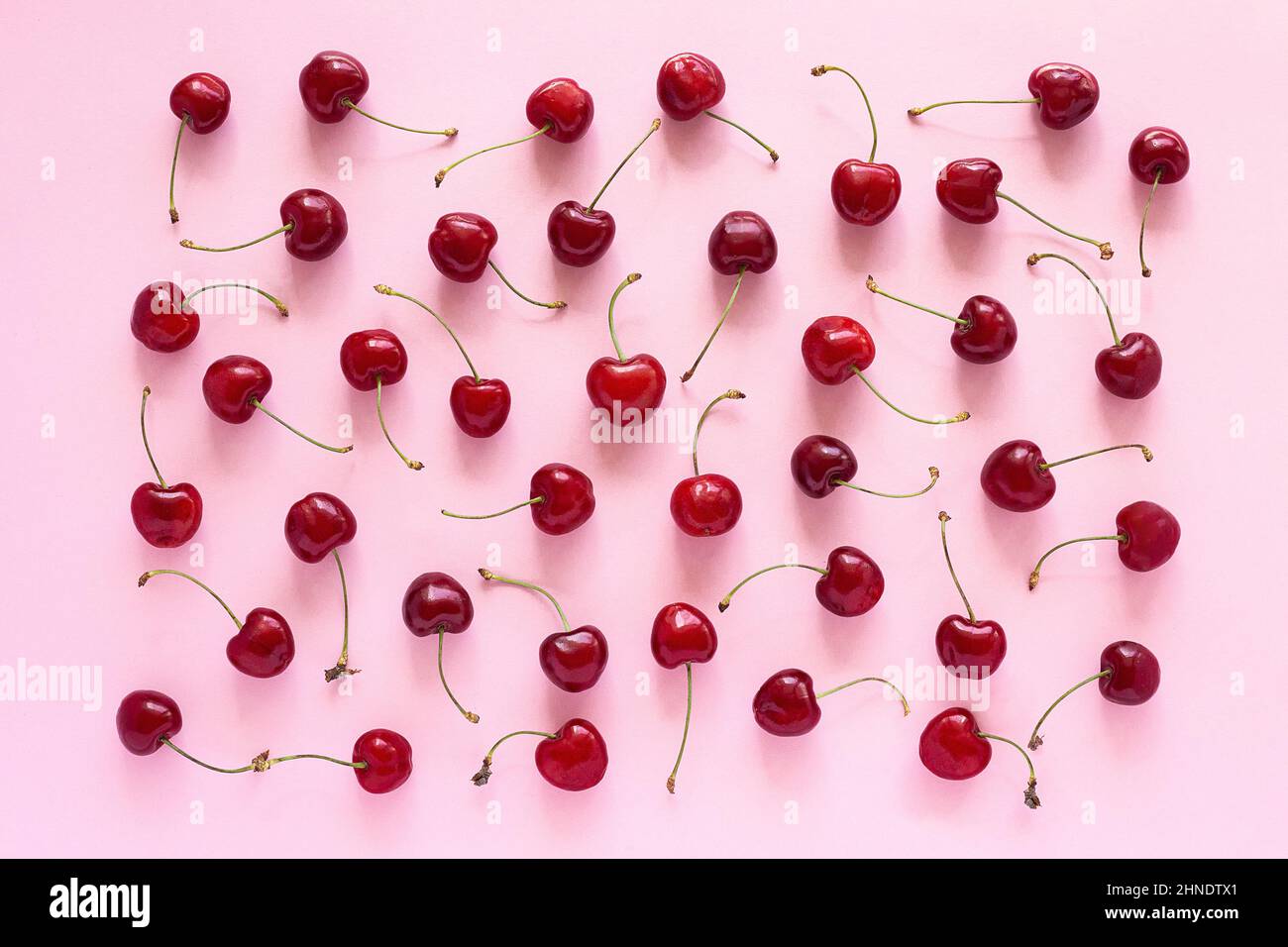 Red ripe sweet cherry on pink background, texture or background Stock Photo - Alamy