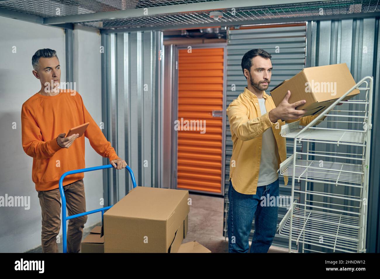 Two storehouse employees unloading goods in the storage room Stock ...