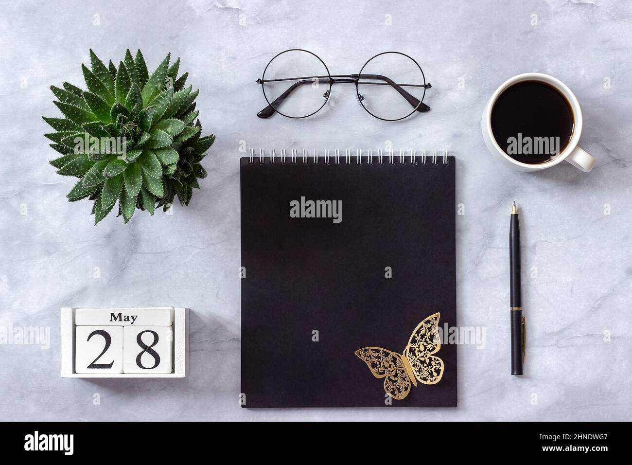 Office or home table desk. Wooden cubes calendar May 28. Black notepad ...
