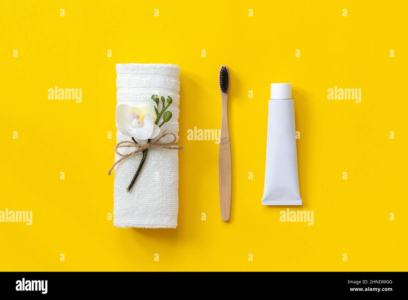 Natural eco-friendly bamboo brush, white towel and tube of toothpaste ...
