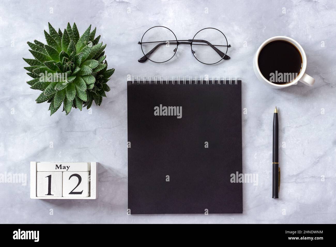 Office or home table desk. Wooden cubes calendar May 12. Black notepad ...