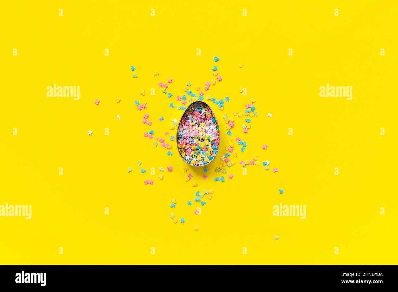 Egg shape form and scattering multicolored confectionery topping ...