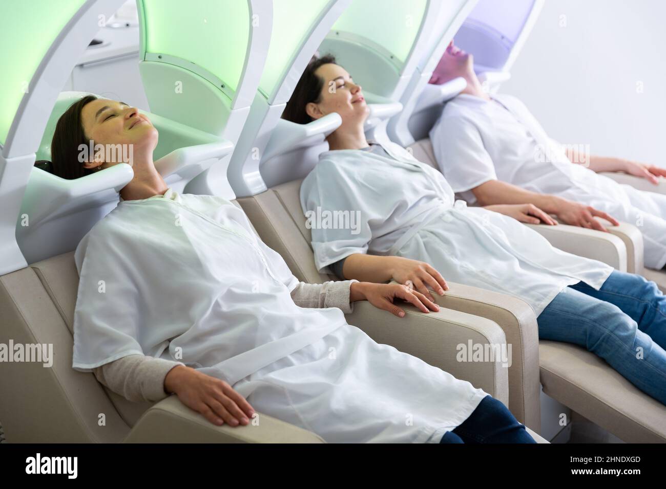Clients of beauty salon relaxing on massaging chairs Stock Photo - Alamy
