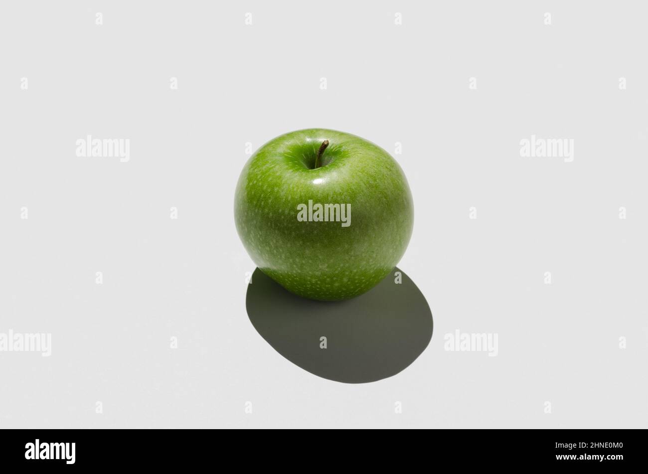 Green apple on a white background. Hard shadow Stock Photo - Alamy