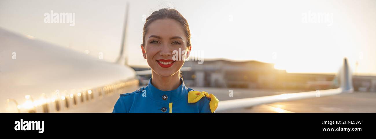 Portrait of beautiful air stewardess with red lips in blue uniform ...
