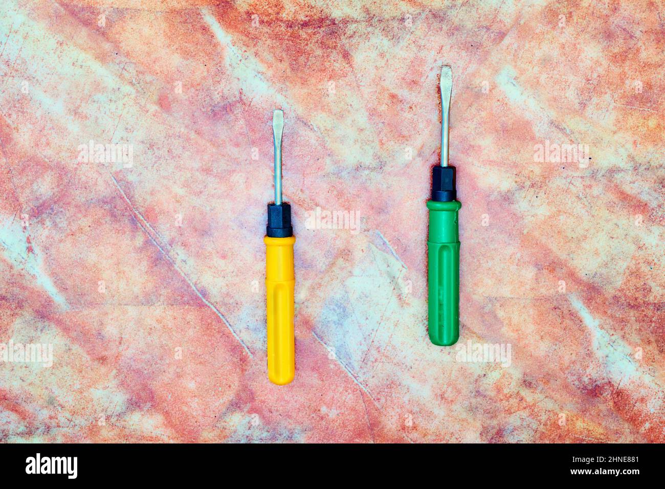 Green and orange screwdrivers on brown marble tiles Stock Photo - Alamy