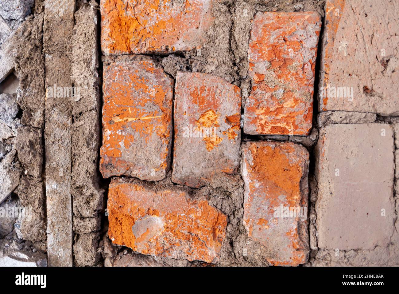 Repair of an old brick wall of a home stove. Different red bricks are ...