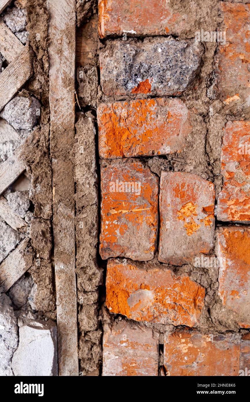 Repair of an old brick wall of a home stove. Different red bricks are ...