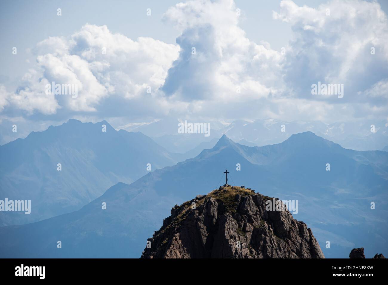The summit of a high mountain with a summit cross in the background a ...