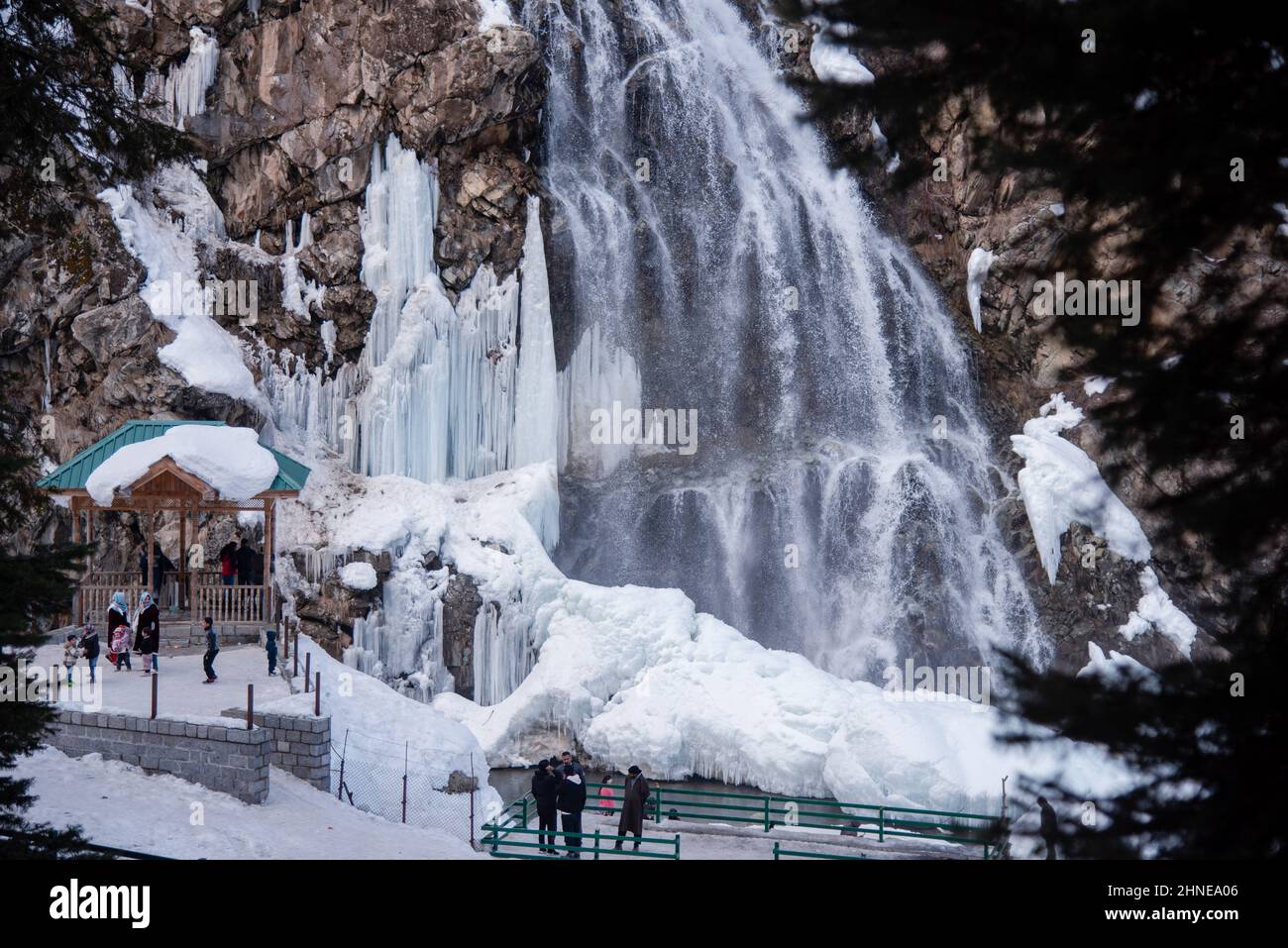 Visitors are seen in front of a partially frozen waterfall in Drung ...