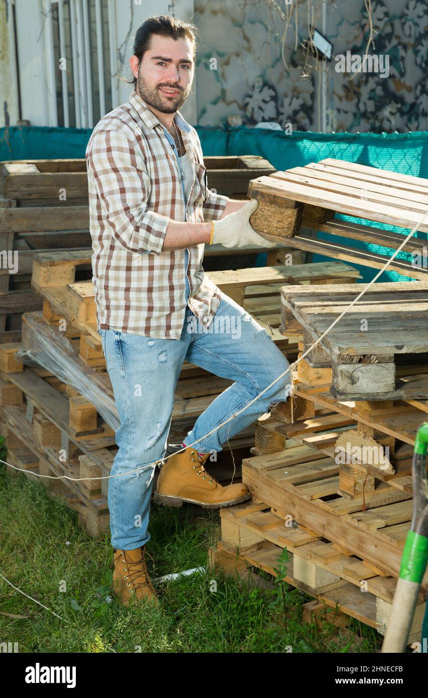 Man working with wooden pallets Stock Photo - Alamy