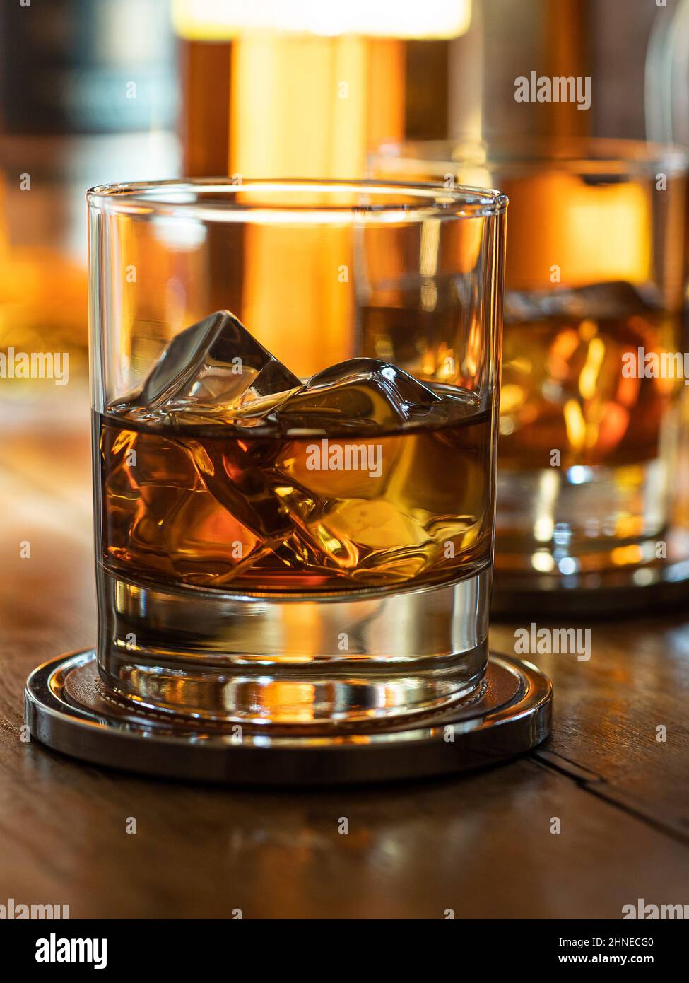 Glass of whisky on the rocks on a wooden bar top Stock Photo - Alamy