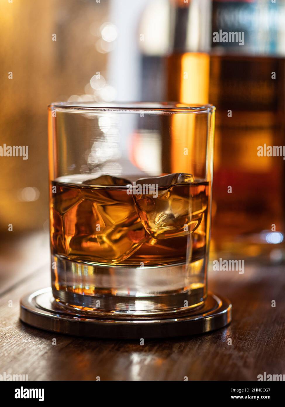 Glass of whisky on the rocks on a wooden bar top Stock Photo - Alamy