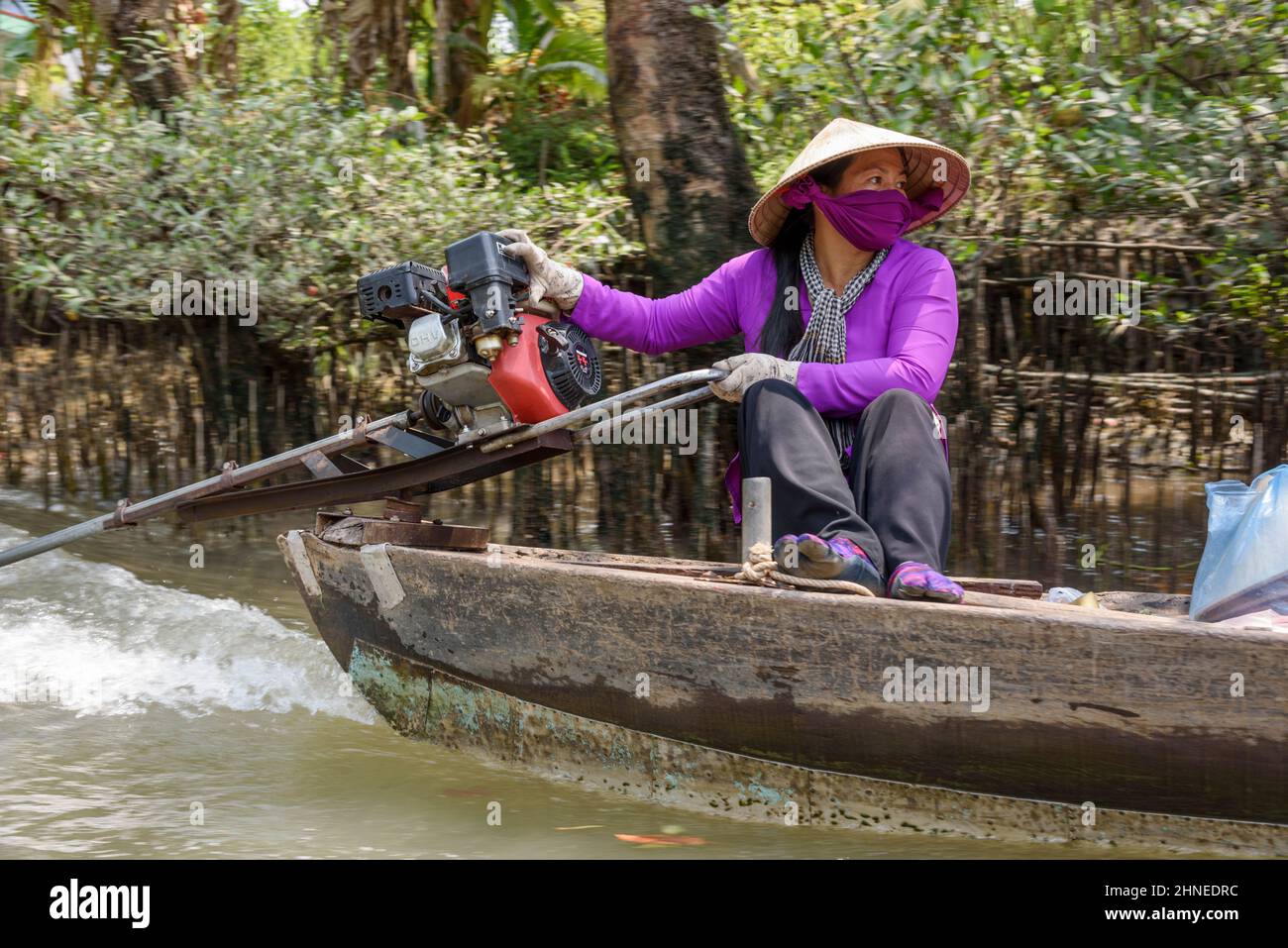 Vietnamese woman with a traditional wooden motor boat (sampan) on the ...