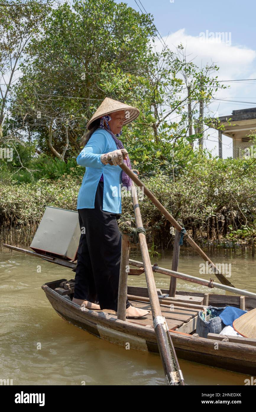 Vietnamese woman with a traditional wooden rowing / motor boat (sampan ...