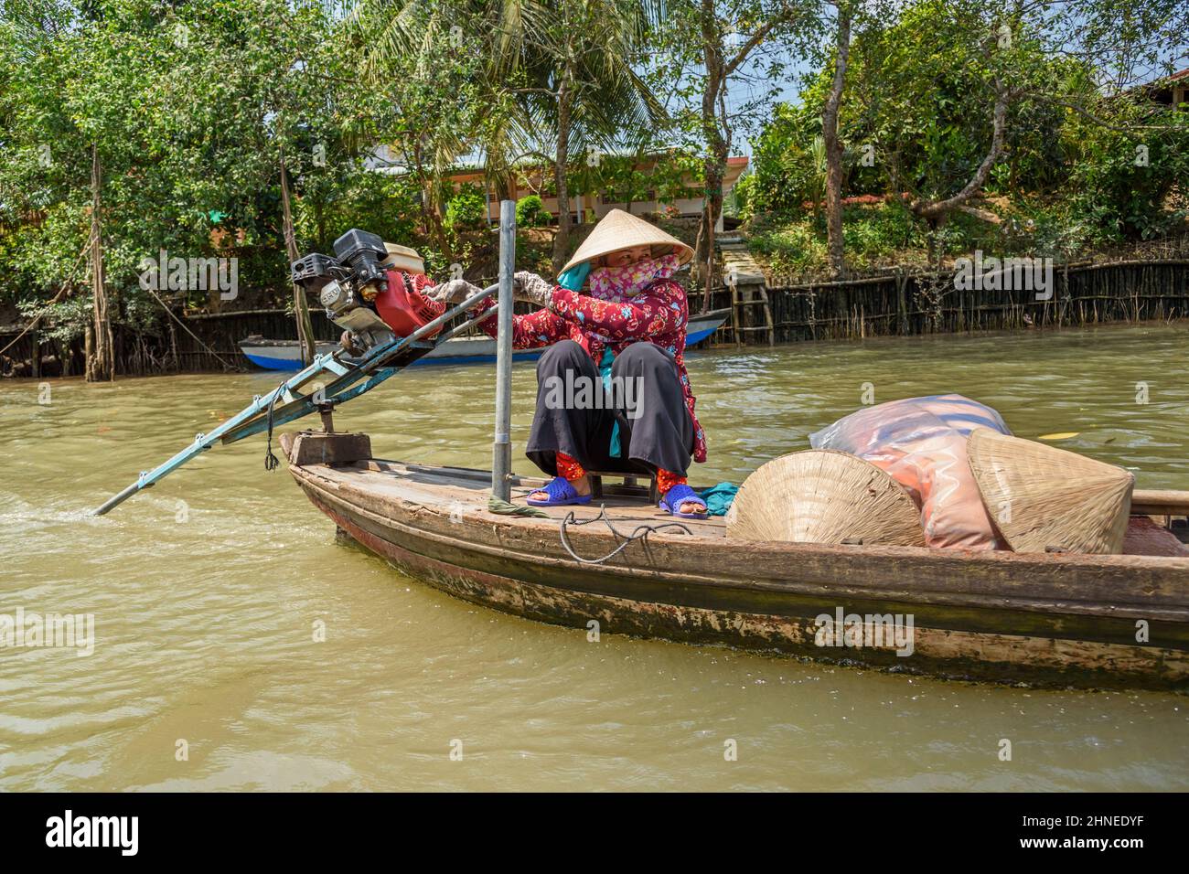 Vietnamese woman with a traditional wooden motor boat (sampan) on the ...