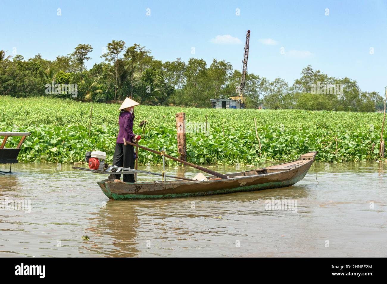 Vietnamese woman with a traditional wooden rowing / motor boat (sampan ...