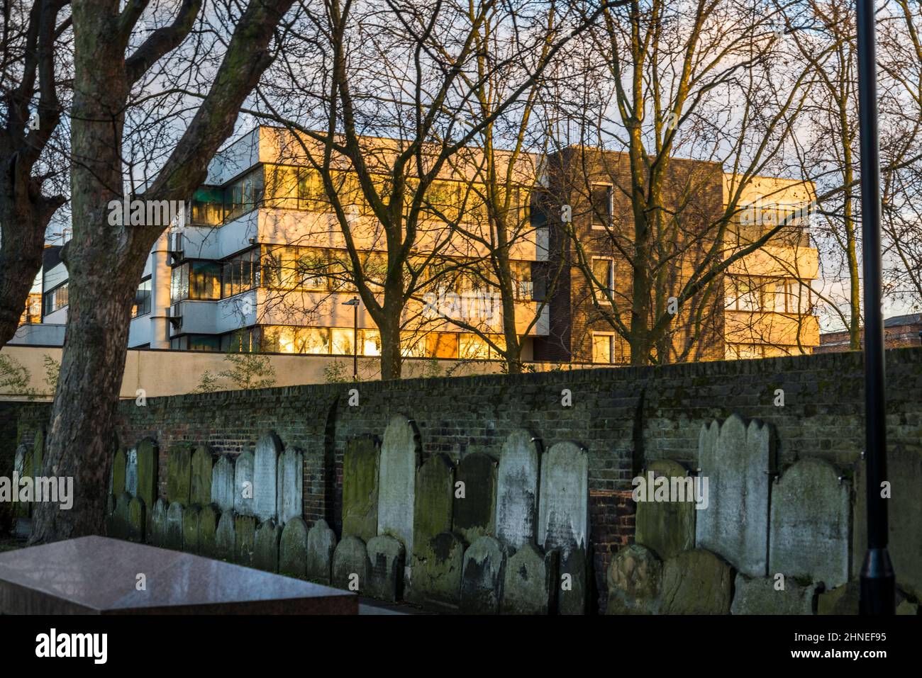 Headstones in the churchyard of St George-in-the-East Church and sunlit ...