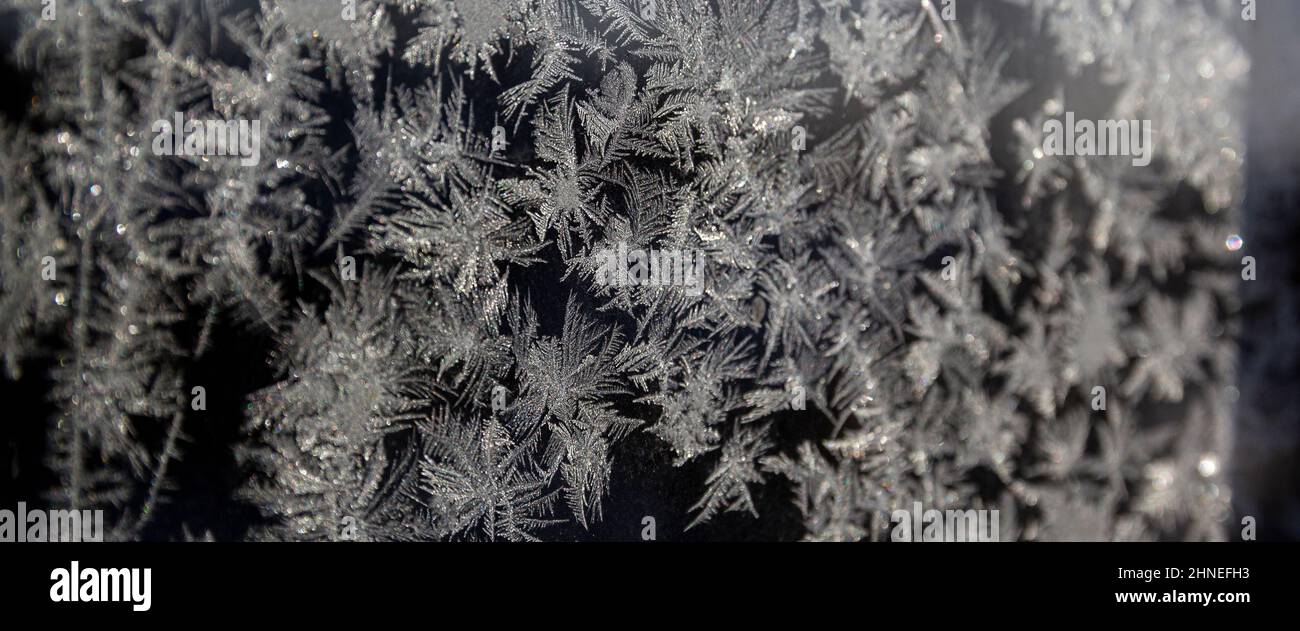 Melting ice running down a window pane, Closeup of frozen window pane ...