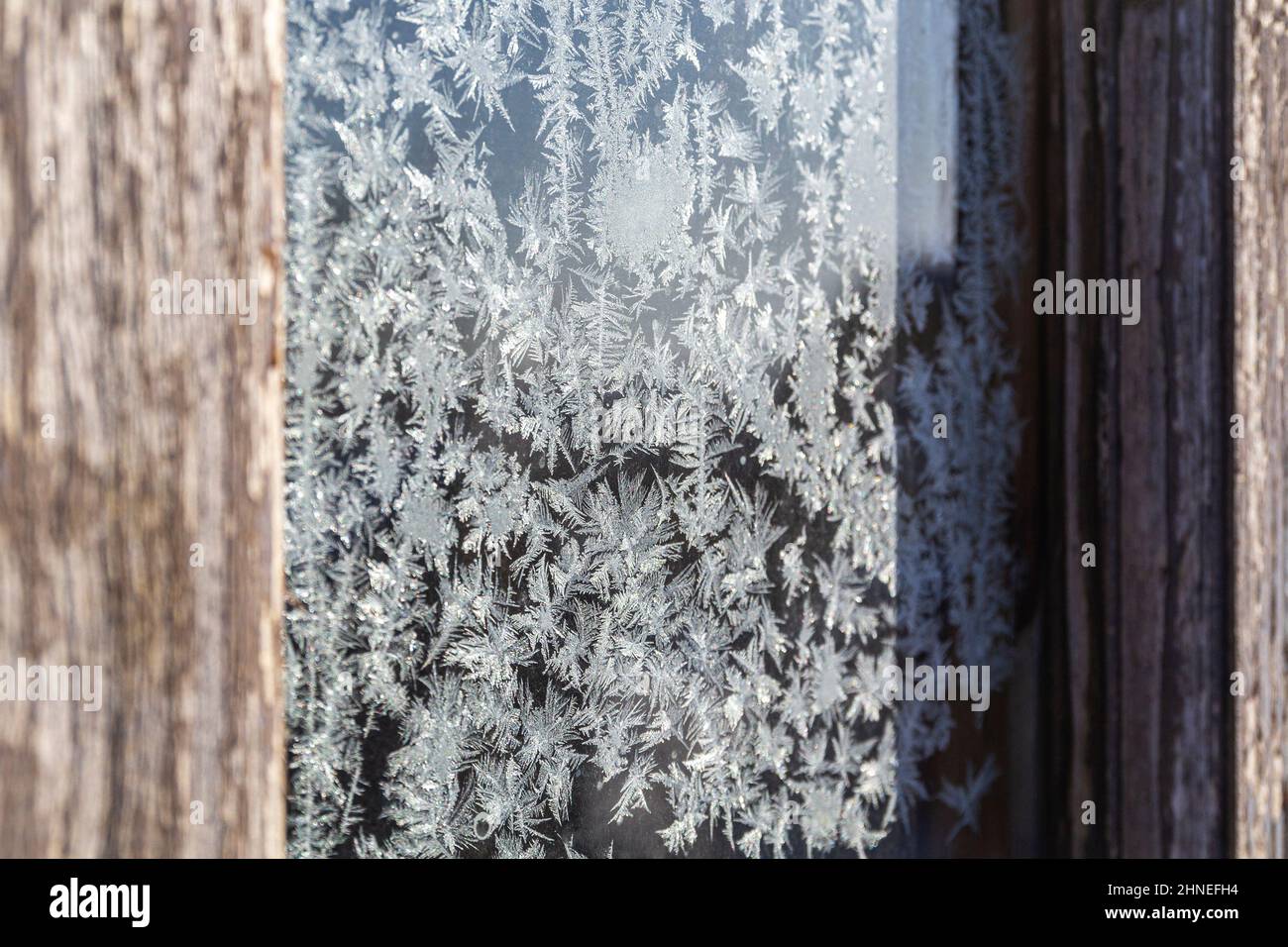 Melting ice running down a window pane, Closeup of frozen window pane surface with ice crystals ...