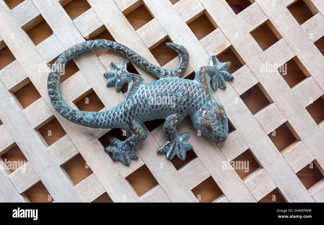 Decorative green lizard made of stone on wooden boards Stock Photo - Alamy