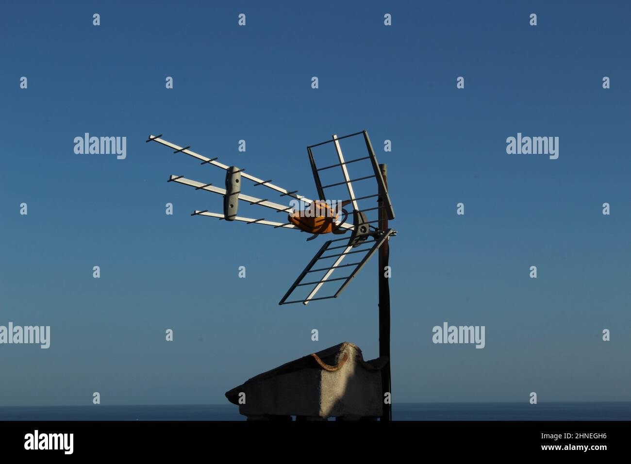 Rooftop TV antenna against a clear blue sky Stock Photo - Alamy