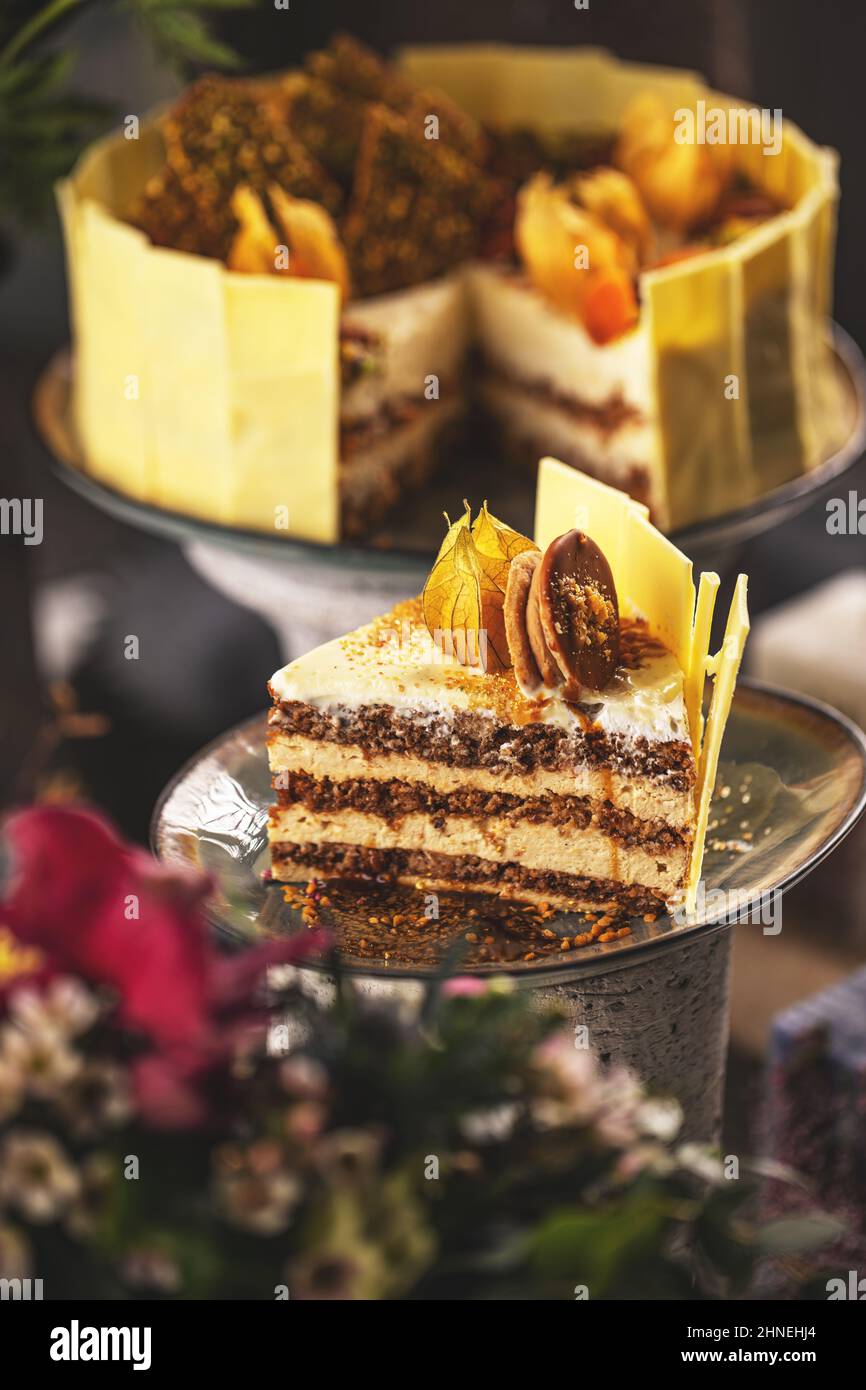 Slice of layered nut cake with mascarpone cream decorated with ...