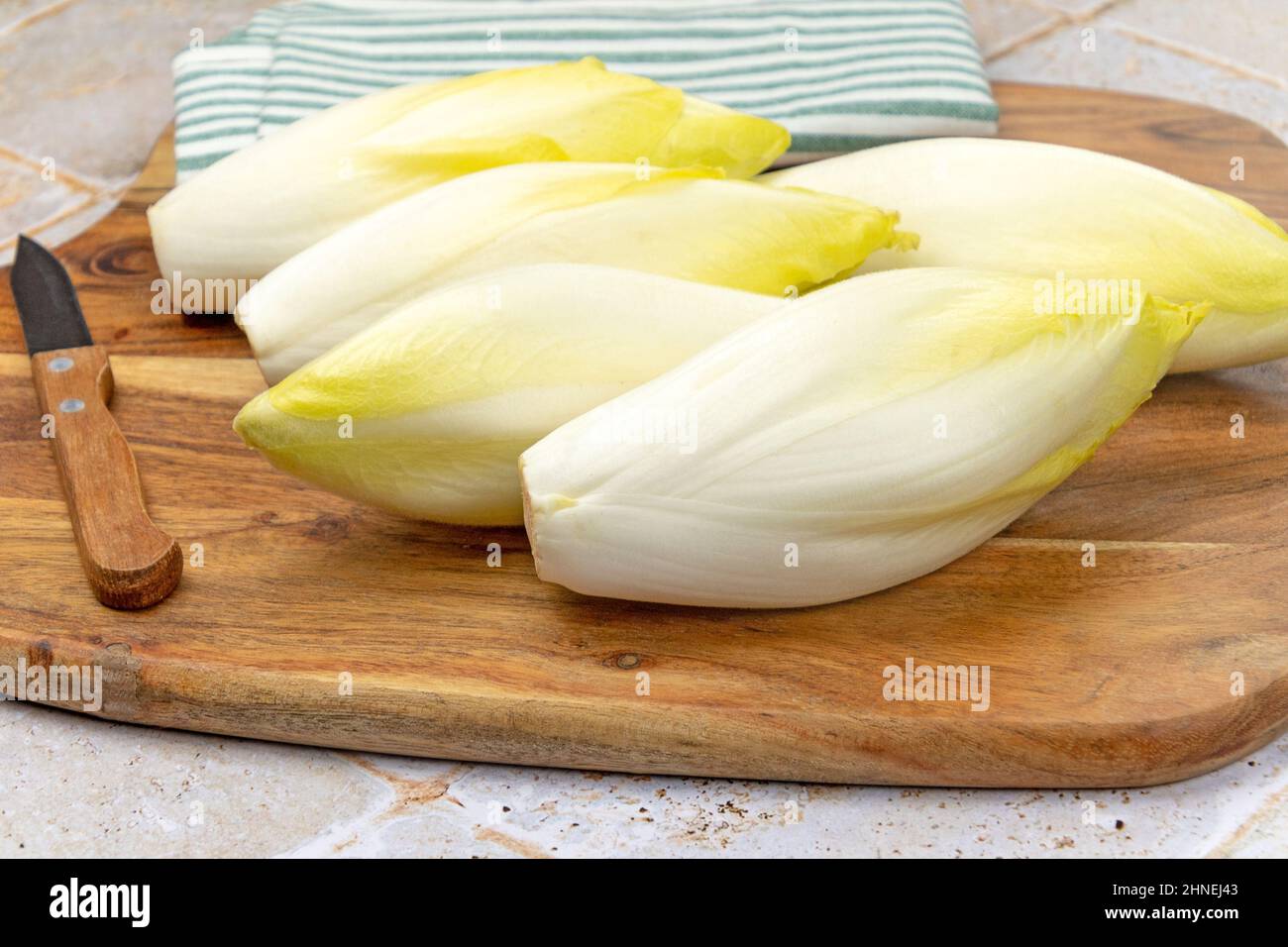 raw endives on a wooden board on a table Stock Photo - Alamy