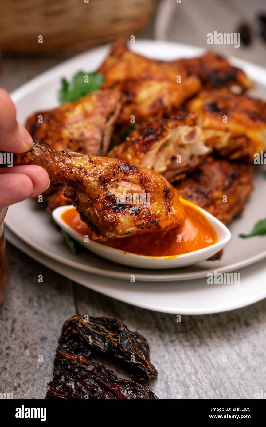 Vertical closeup shot of a person eating fried chicken legs with sauce ...