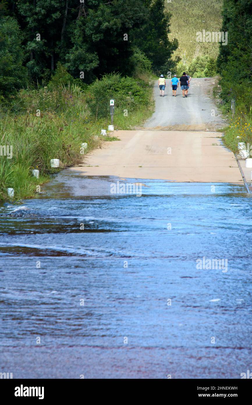 Water over low-water bridge in countryside with hikers Stock Photo - Alamy